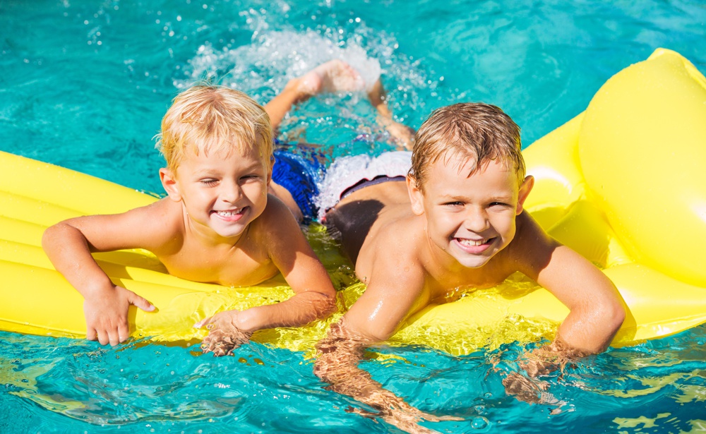 Young Kids Having Fun In Swimming Pool On Yellow Raft Summer Vacation 